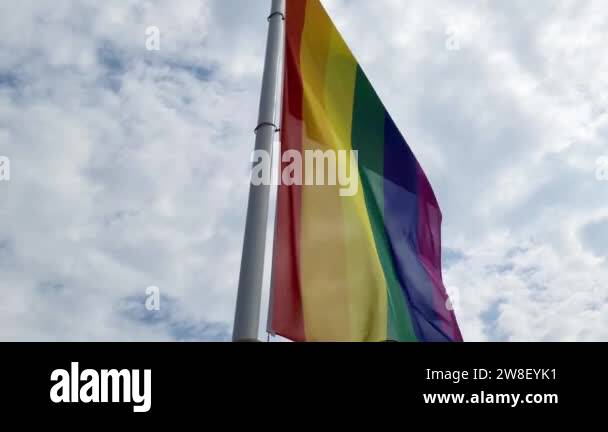 Rainbow pride flag waving in the wind on a flag pole. Lgbt community ...