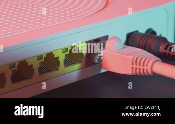 Closeup: connect the RJ45 cable to the white WiFi router. Switch on ...