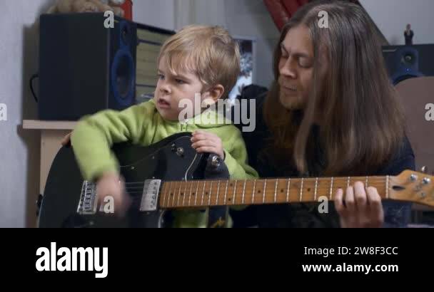 Young Rocker Musician Man Teaches Child Playing on Electric Guitar ...