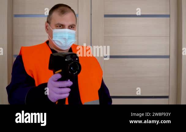 guard checks the temperature with a thermal imager when entering the ...