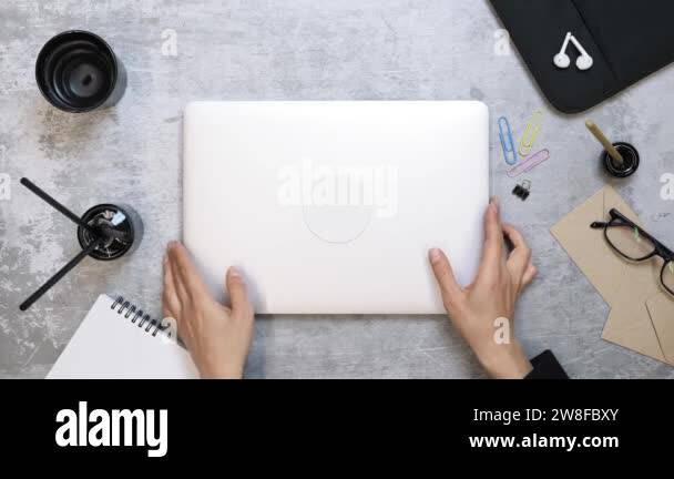 Female hands take off laptop computer from office work table. Office ...