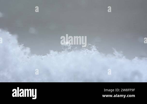 Snow falls window close-up. Macro background of snowflakes. Slowly ...