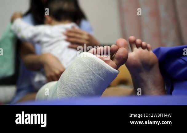 Selective focus gypsum of mother due to broken leg. Mother hug baby at ...