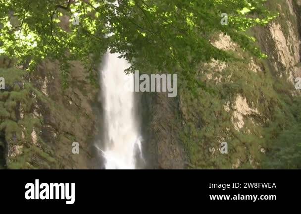 Mountain waterfall. A fast mountain river falls down a cliff. The ...