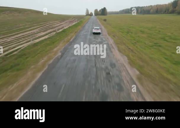 Aerial view of white electric car driving on countryside road. Modern ...