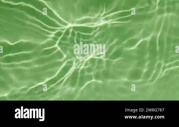 Water splash green colored. Drop falls into water and diverging circles ...