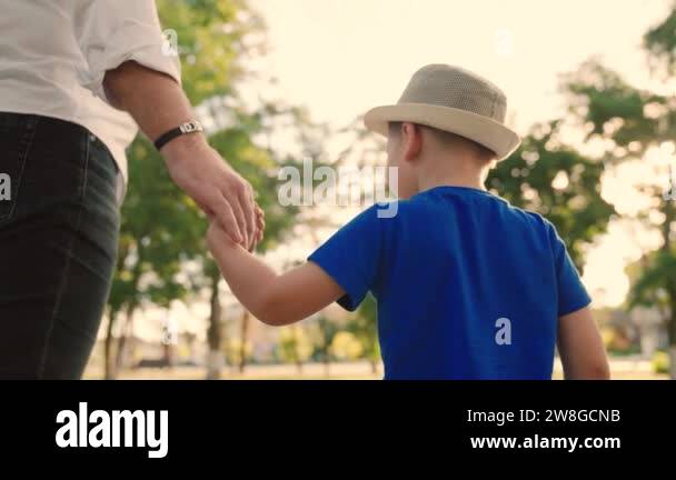 Dad, child, son are walking together in the park, holding hands. Dreams ...