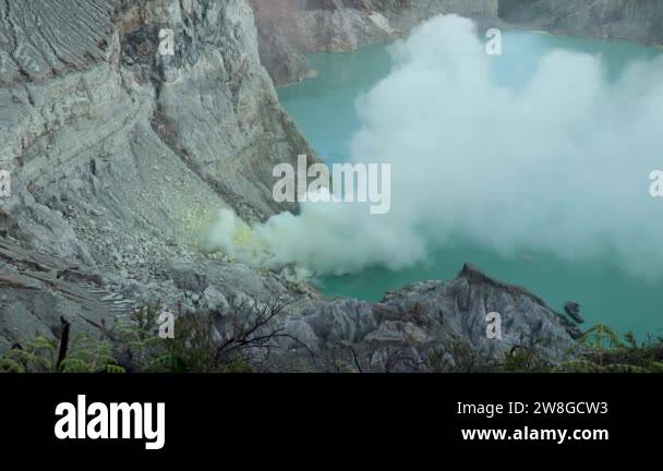 crater acid lake Kawah Ijen where sulfur is mined. Sulfur gas, smoke ...