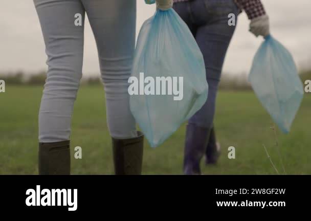 volunteers collect garbage in garbage bags, protect nature from ...