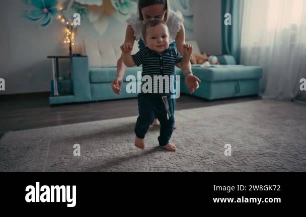 Cute smiling baby boy learning to walk. Babys First Steps. Baby making ...