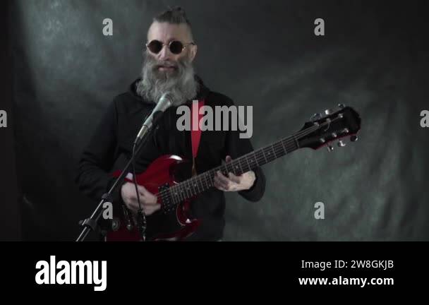 Bearded hairy rockstar in retro round sunglasses and black hoodie with ...