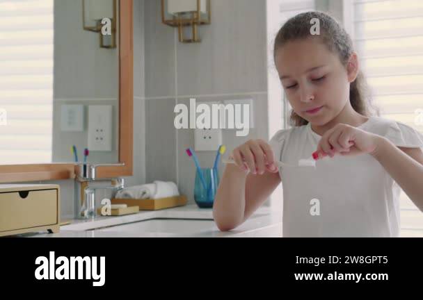 Portrait happy cute young teenage girl squeezing toothpaste onto ...
