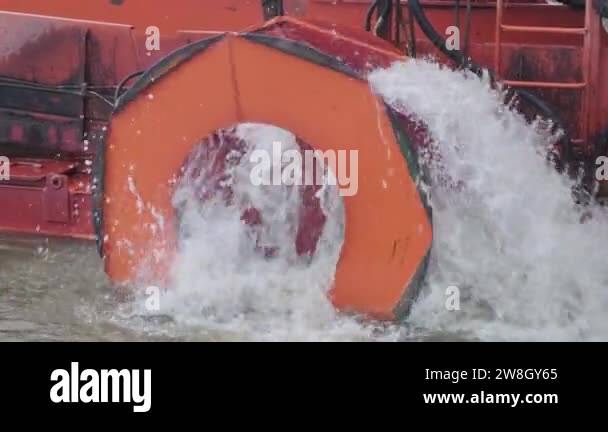 Worker on a weed clearing water tractor (or aquatic weed harvester ...