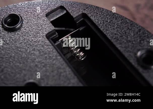 Empty battery compartment of a black plastic electronic device with a ...