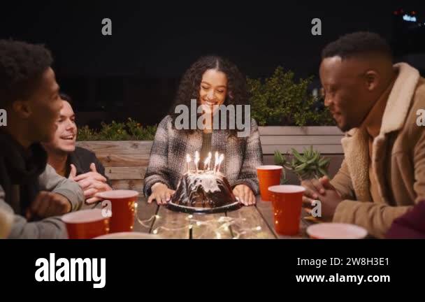 Diverse group of friends singing happy birthday to Multi-culturalfemale ...