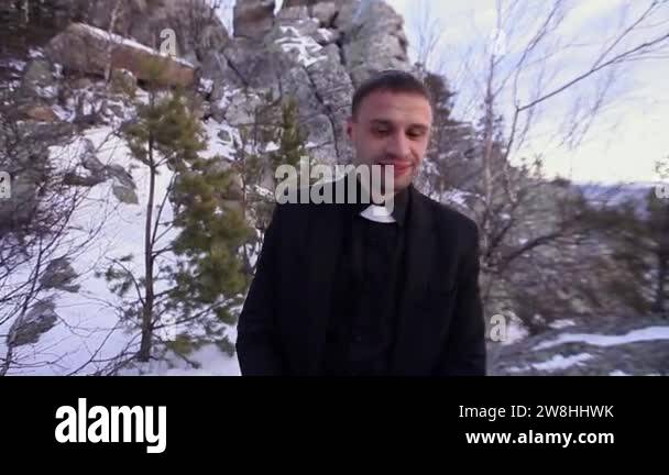 the priest preaches on the mountain. A man in the clothes of a pastor ...