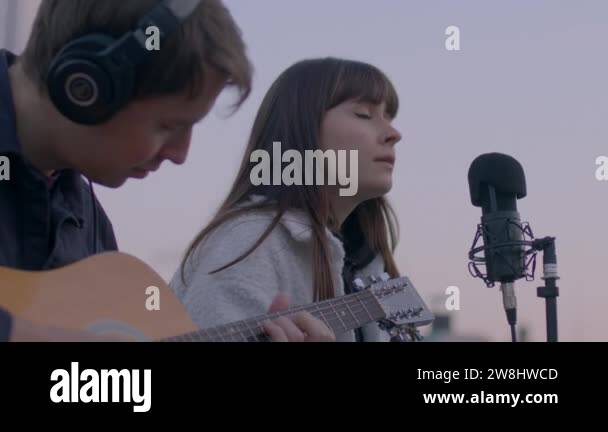 Girl with closed eyes singing into a mic. The inspired female singer ...
