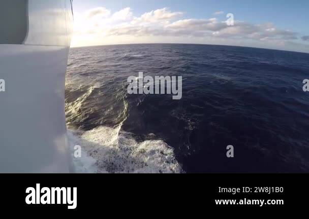 Bow of the big ship hit the huge vawe and make a tall splash and spray ...