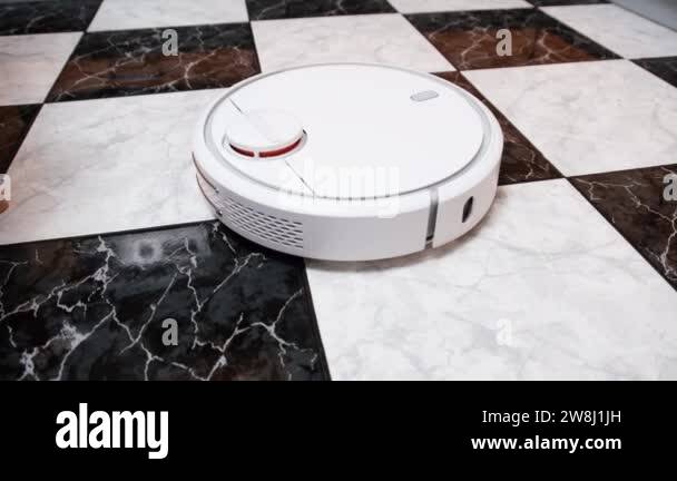 The Robot Vacuum Cleaner Cleans in the Modern House on the Tiles Floor ...