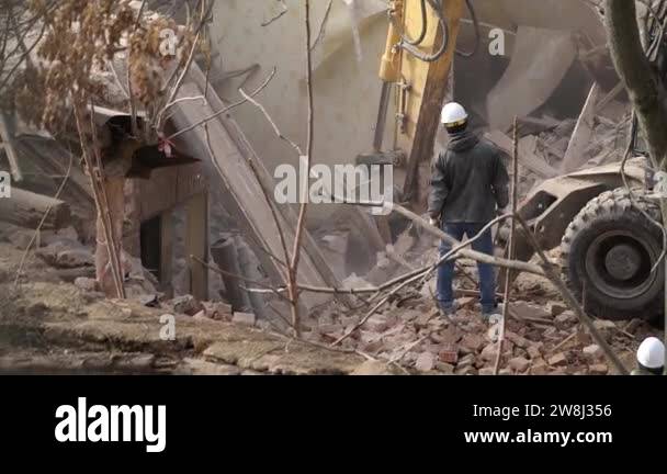 Engineer with protective helmet looks at demolition, destruction of old ...