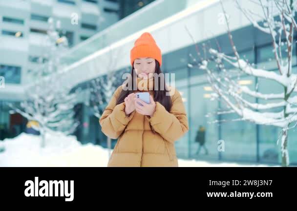 Beautiful happy asian teen girl student stand on winter snow city ...