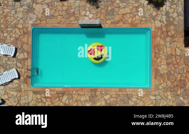 Aerial view of smile emoji float at swimming pool. Float smile emoji ...