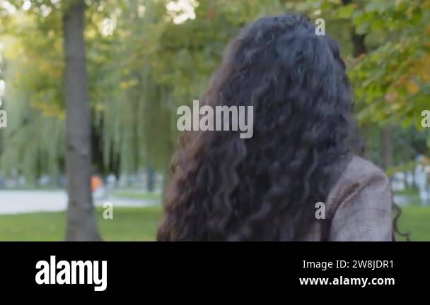 Close up back view active jumping moving dancing brunette with curly ...
