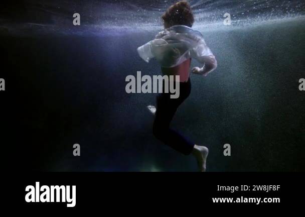 little boy is floundering underwater, floating inside water of swimming ...