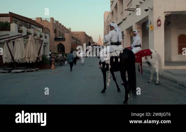 Souq Waqif Doha, Qatar main street afternoon shot showing traditional policemen riding horses ...