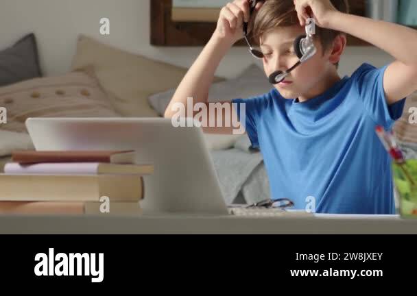 smiling student boy studying at home with remote school connected to ...