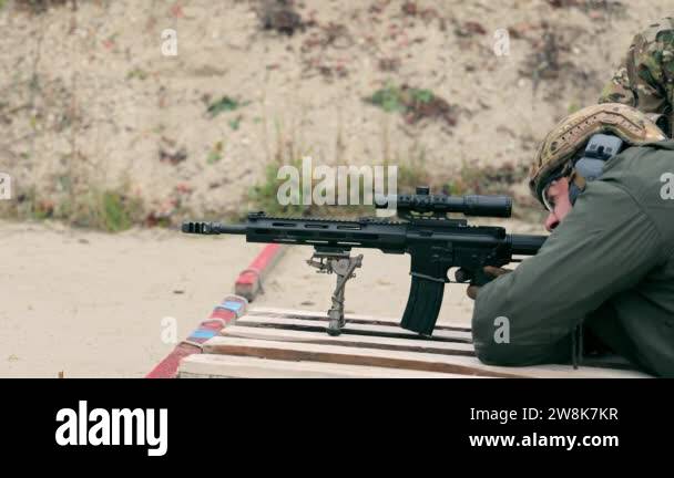 Shot of a sniper lying down holding a sniper rifle. Fighting and a ...