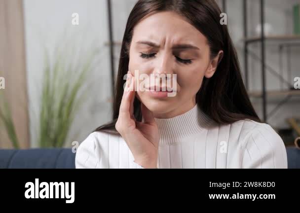 Woman touch cheek, suffers from toothache, terrible sudden tooth pain ...