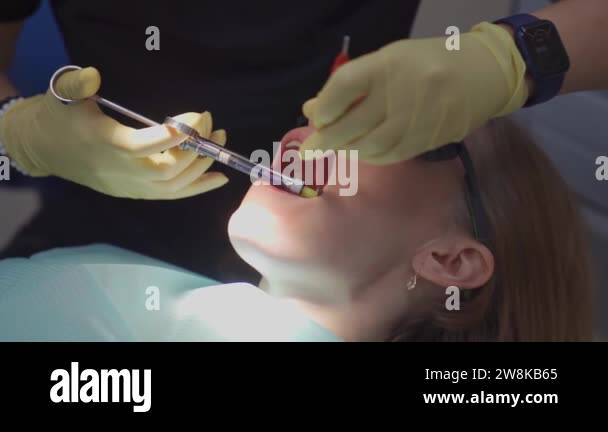 real. dentist injects an anesthetic into patient before tooth ...