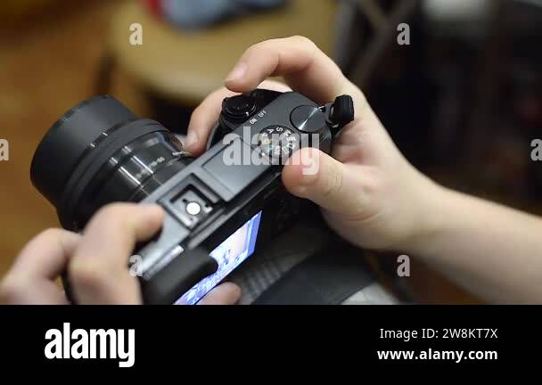 She sets up the camera before shooting. Man turns the wheels of the ...