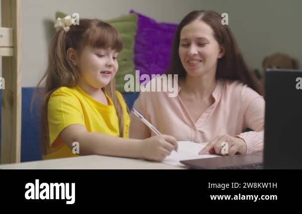 little child writes homework with a pen in a notebook, a kid does ...