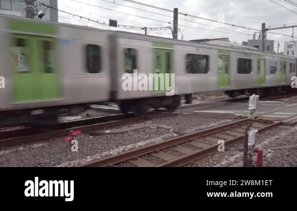 tokyo, japan - november 25 2021: Pan video of an E235 series train passing on the railway track ...