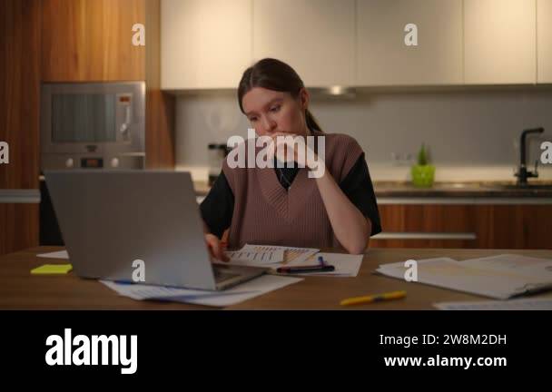 A brooding woman looks into a computer monitor while working from home. Create to invent ...