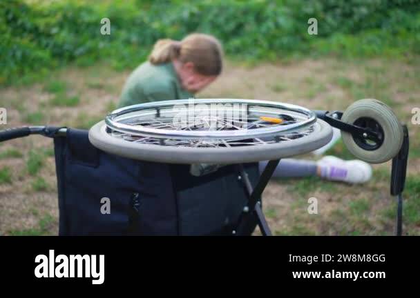 Wheel of rolled over wheelchair spinning with blurred disabled girl ...