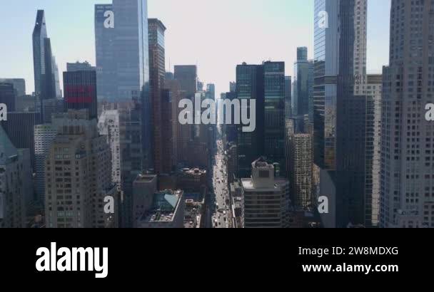 Elevated view of long straight wide street between tall modern downtown ...