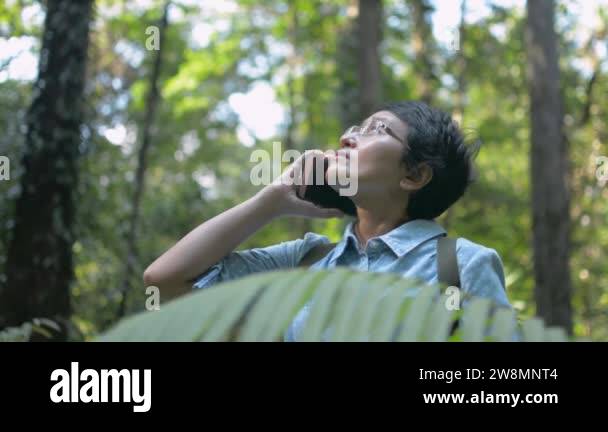 Asian woman nature explorer using mobile smartphone talking to her ...