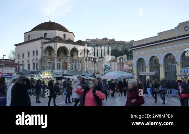 Two women in people crowd point to the direction on Monastiraki Square ...