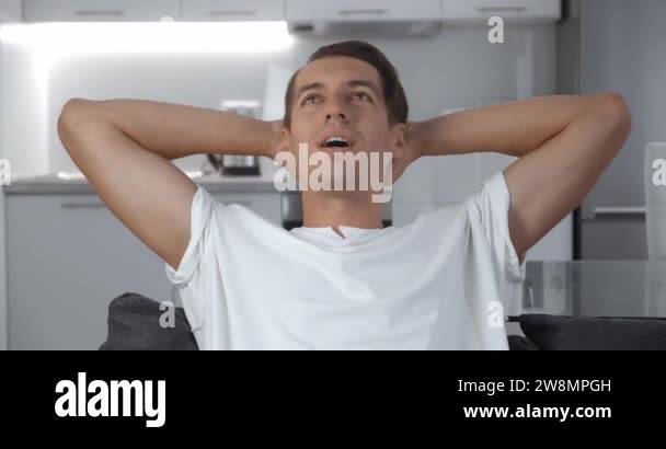 Calm relaxed smiling man resting on cozy sofa at home. Happy young male ...
