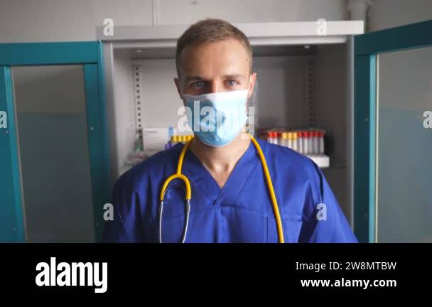 Portrait of young doctor take off medical face mask and smile. Medical ...