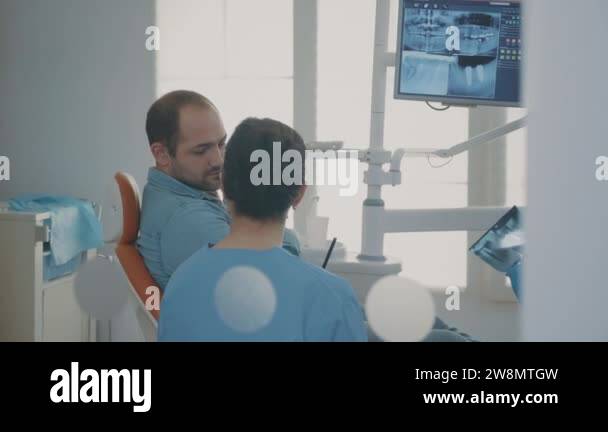 Dentist and nurse explaining x ray scan to patient with toothache Stock ...