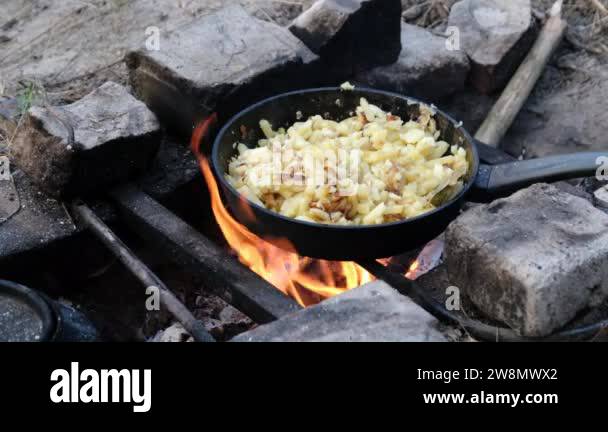 Fried Potatoes are Cooking in Frying Pan over a Fire Outdoor on Self ...