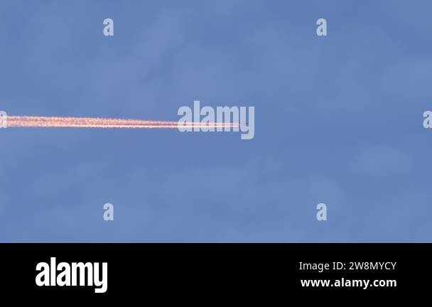 Distant passenger jet plane flying on high altitude on clear blue sky ...