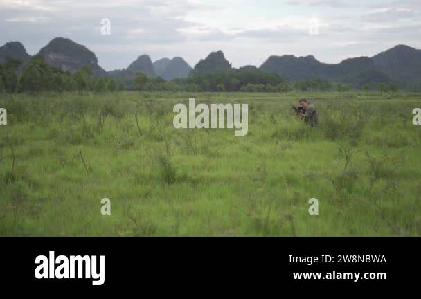 Soldier positioning and running through battlefield in countryside ...