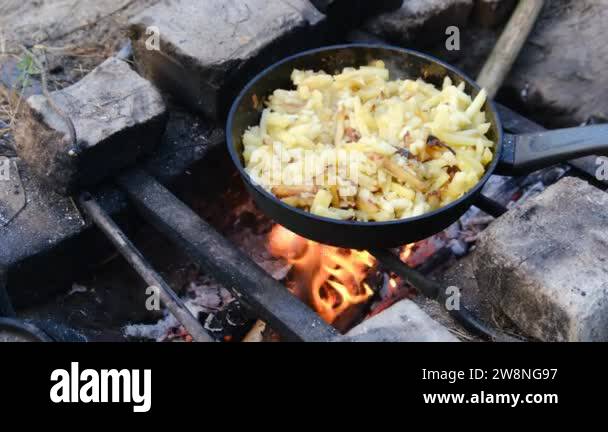 Fried Potatoes are Cooking in Frying Pan over a Fire Outdoor on Self ...