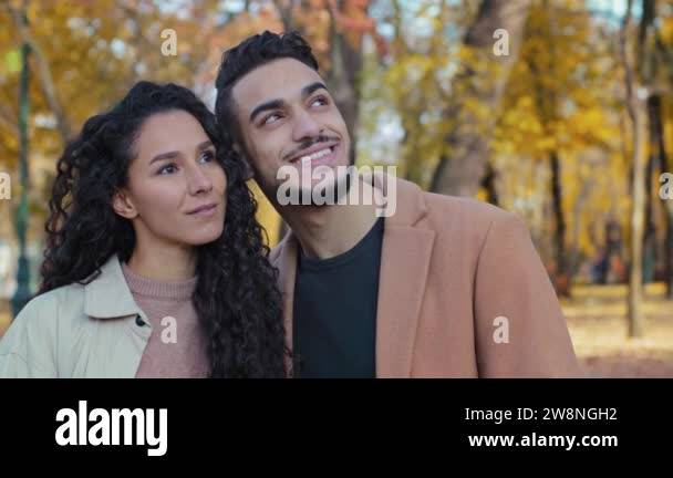 Close-up happy hispanic couple on date in autumn park hug partners ...