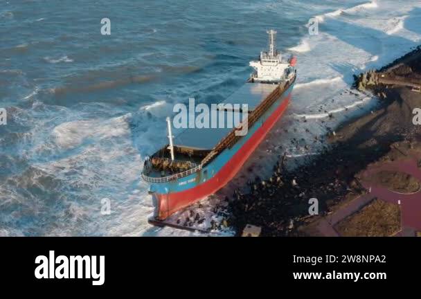 A large seagoing vessel dry cargo ship washed ashore during a strong ...